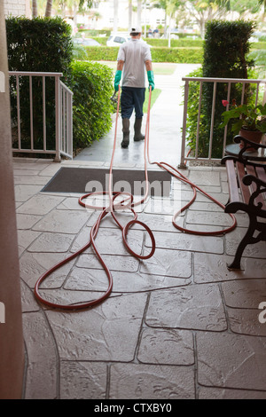 Man walking and pulling a high pressure washer machine isolated on ...