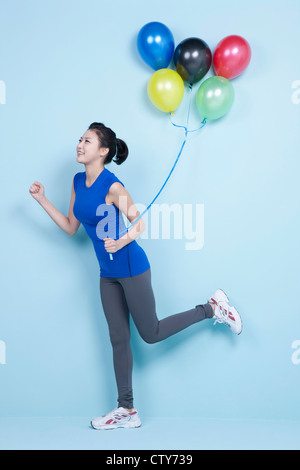 A jogging man and woman with colorful balloons Stock Photo - Alamy