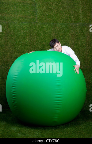 A man hugging a green ball Stock Photo - Alamy