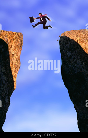 Businessman jumping over the cliff Stock Photo - Alamy
