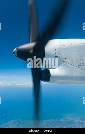 Aeroplane wing as seen from inside of flight through window. Clouds and ...