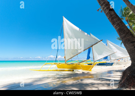 traditional paraw sailing boats on white beach on boracay island ...