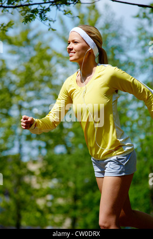 Portrait of a young woman jogging with a walkman Stock Photo - Alamy