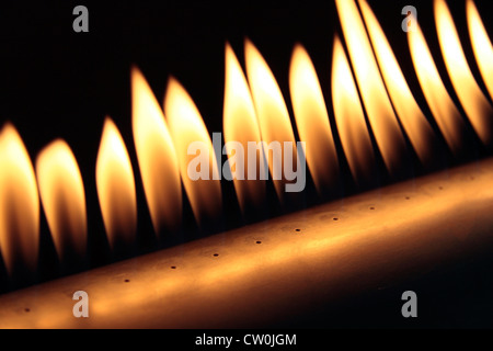 Methane gas burning bright yellow/orange in a line of single flames ...