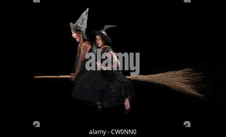 two scared witches flying on a broom. Black background Stock Photo - Alamy