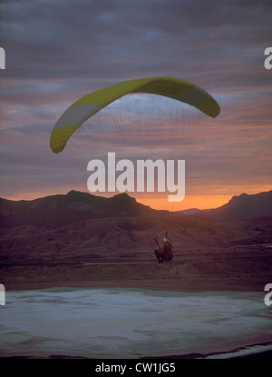 Paragliding pilot flying red paraglider with snow covered peaks in ...