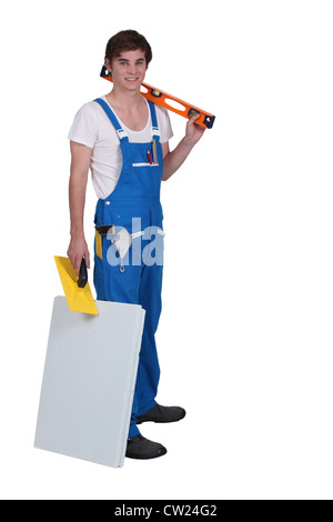 Young tradesman posing with his tools and materials Stock Photo - Alamy