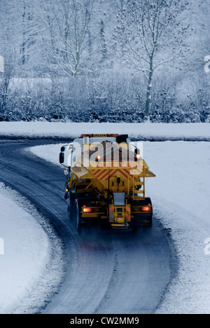 Gritting truck spreading grit on street with snow tractor ahead turning ...