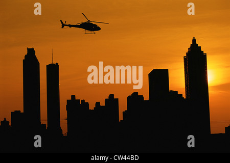 Helicopter flying over Atlanta skyline at sunset Stock Photo - Alamy