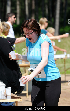 Runners taking on cold refreshments of water during a hot summers day ...