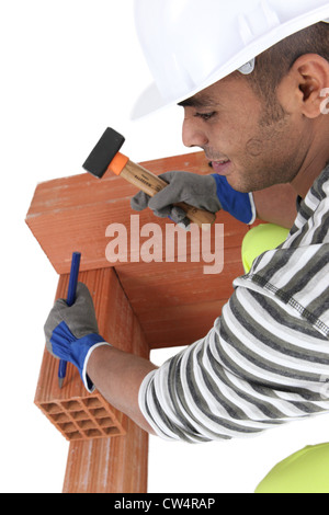 Builder chiseling a brick Stock Photo - Alamy