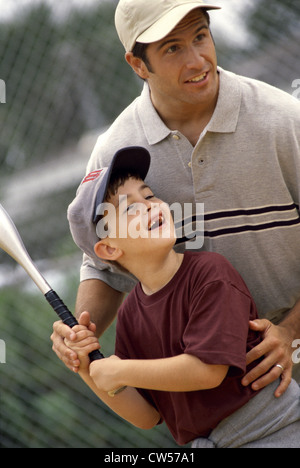 father teaching his son how to play baseball in front of cardboard ...