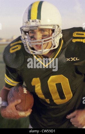 Football player carrying his helmet Stock Photo - Alamy