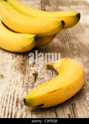 Banana bunch on a light wooden background Stock Photo - Alamy