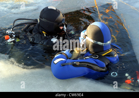 ice diver preparing to dive into frozen lake, Germany, North Rhine ...