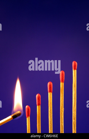 burning matchstick inflaming a row of matchsticks Stock Photo - Alamy
