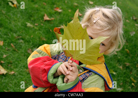 Little child is hiding something behind her back Stock Photo - Alamy