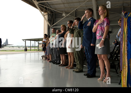 Family members stand for the national anthem during a retirement ...