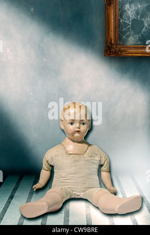 Old neglected doll sitting in front of derelict building Stock Photo ...