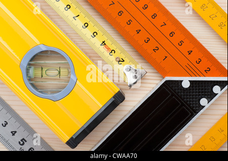 Assorted construction and measurement tools arranged on a wooden ...