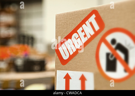 A close-up of a cardboard package corner shows a white caution sticker ...