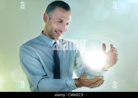 Composite image of businessman holding light bulb and pointing Stock ...