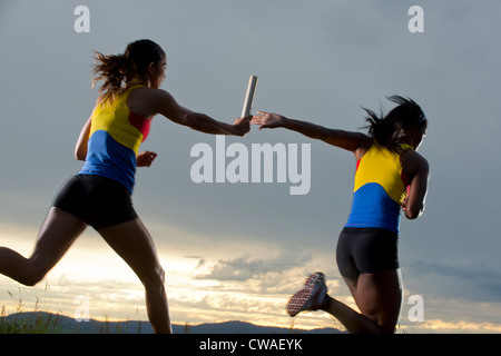 Relay baton, cooperation, teamwork concept. Hands of two sportsmen ...