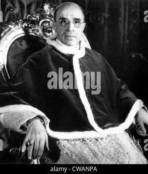 Pope Pius XII, wearing the ring of St. Peter, raises his right hand in ...