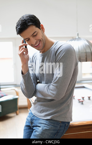 Man leaning against a pool table using a mobile phone Stock Photo - Alamy