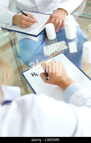 Closeup image of doctor prescribing medicine to patient and writing ...