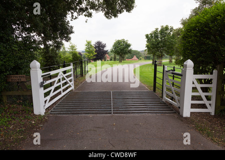 The cattle grid and driveway at the entrance to a country estate or ...