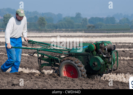 Man plowing a field using hand motor plow Stock Photo - Alamy