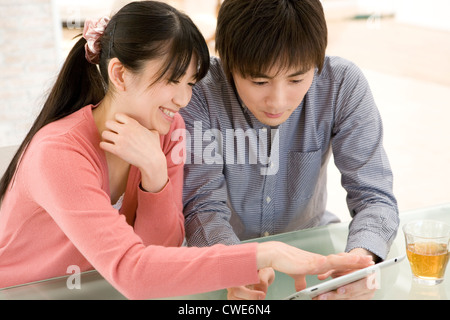 casual young couple using tablet together on couch at home Stock Photo ...