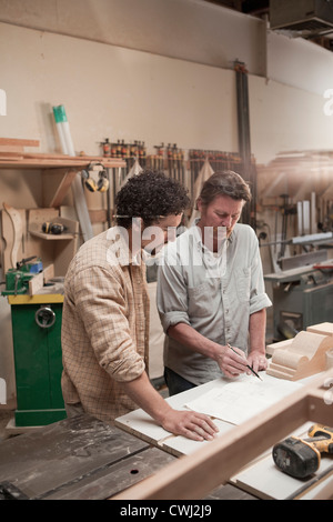 Young workers working in a woodworking factory, Using a nailing machine ...