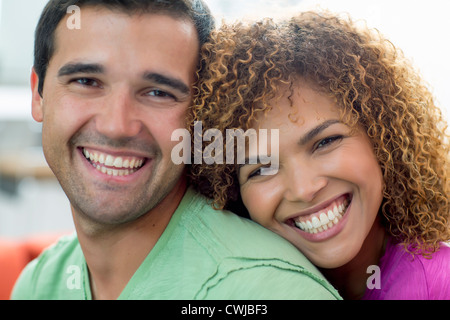 Portrait of smiling mixed-race couple posing over yellow background in ...