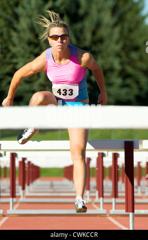 athlete jumping over a hurdles Stock Photo - Alamy