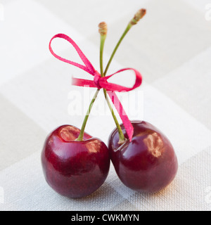 Isolated sweet cherries. Two cherry fruit, one cut in half with pit ...