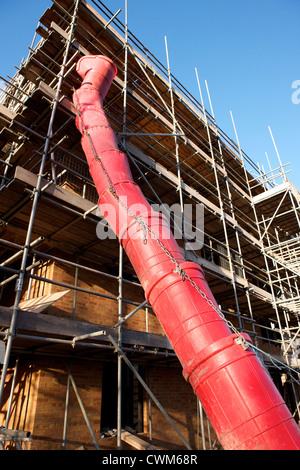Rubbish Chute On Building Site taking the waste into a skip at the ...