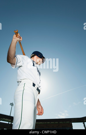 Baseball player holding bat across shoulders Stock Photo - Alamy
