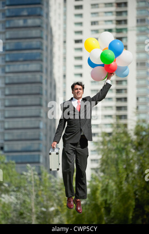 The businessman flying on balloon in challenge concept Stock Photo - Alamy