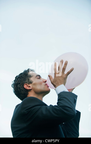 man blowing up balloon from helium tank Stock Photo - Alamy