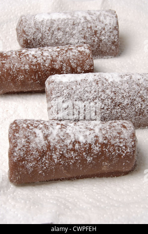 Chocolate logs dusted with icing sugar on a white background Stock ...