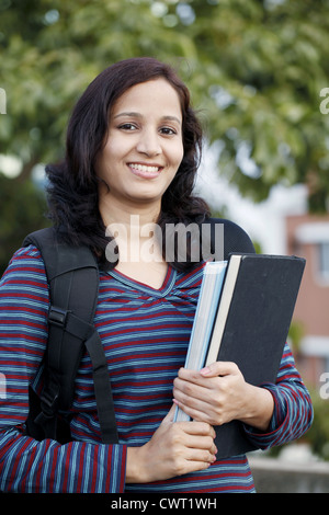 Asian beautiful female student holding book in library Stock Photo - Alamy