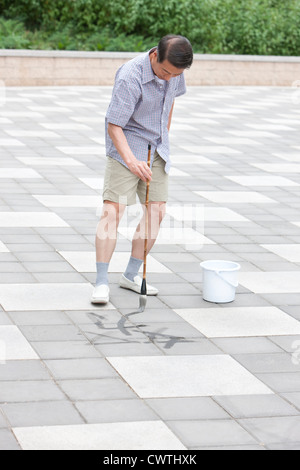 Old man practicing calligraphy in park Stock Photo - Alamy