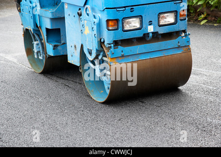 construction worker on a utility roller laying new tarmac driveway in ...
