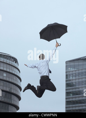businessman defending with umbrella concept Stock Photo - Alamy