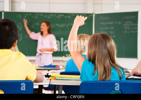 Boy putting his hand up in classroom Stock Photo, Royalty Free Image ...