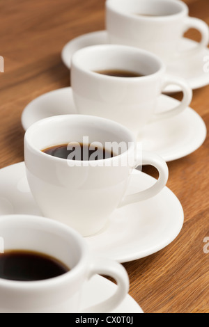 white coffee cup row with saucer and spoon on table Stock Photo - Alamy