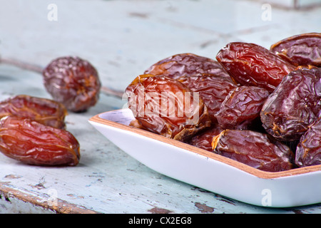Dried dates on rustic wooden board on white wooden table, top view ...