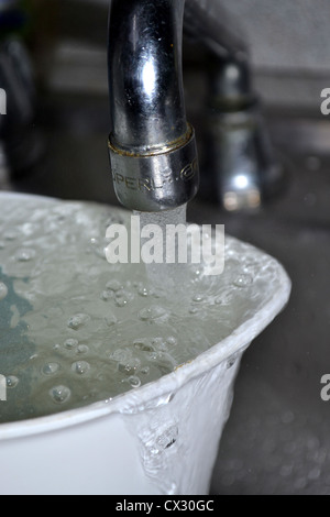 overflowing with water kettle / jug under tap / faucet Stock Photo - Alamy